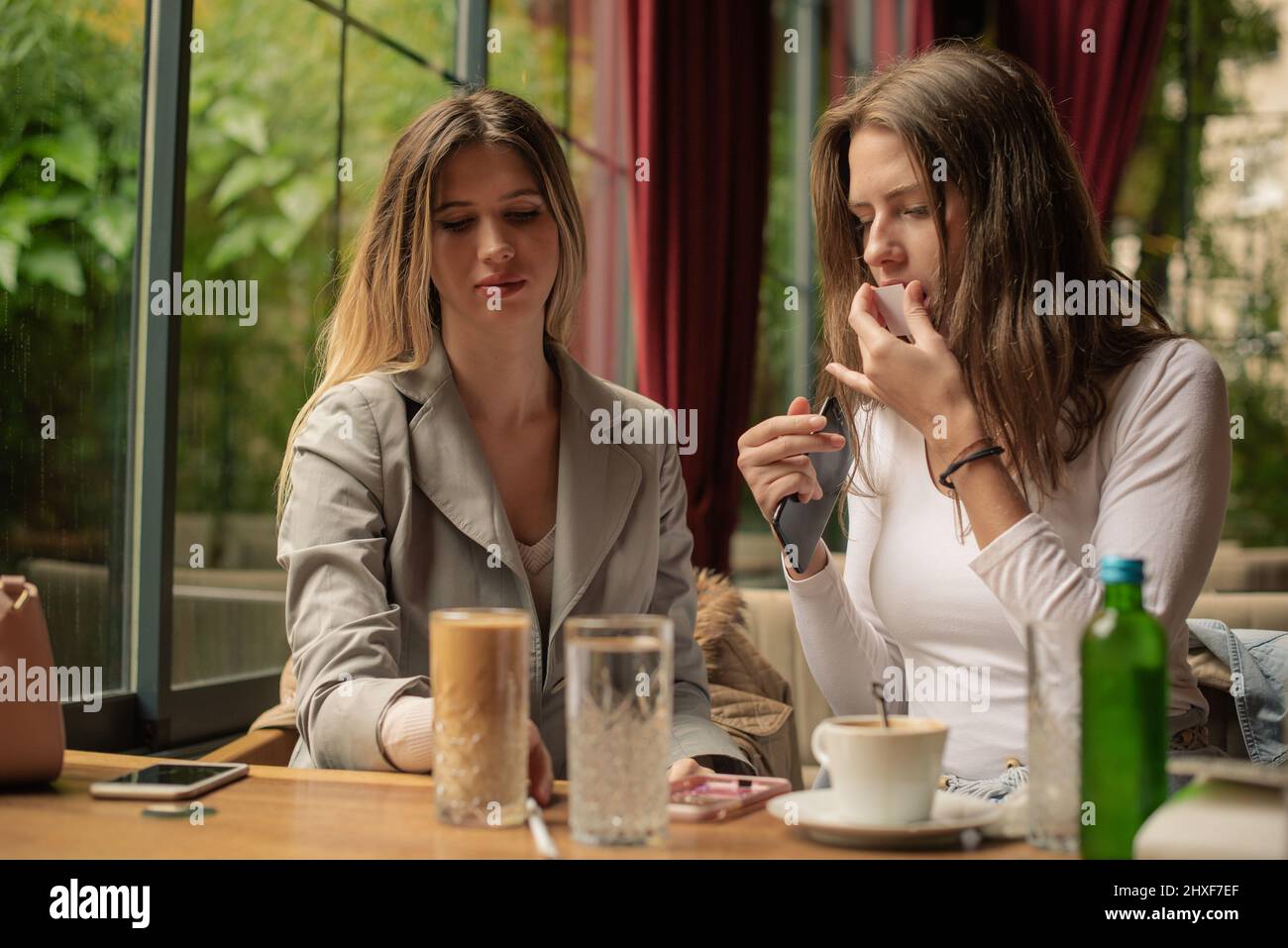 Two attractive and beautiful sisters are trying something while ...