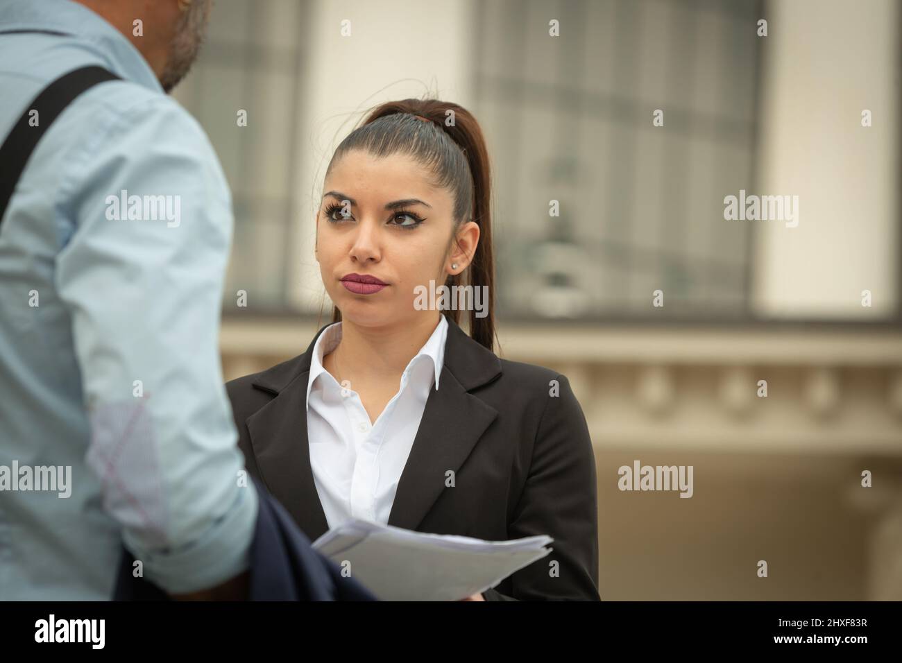 Italian businesswoman is giving the documents to her business partner ...