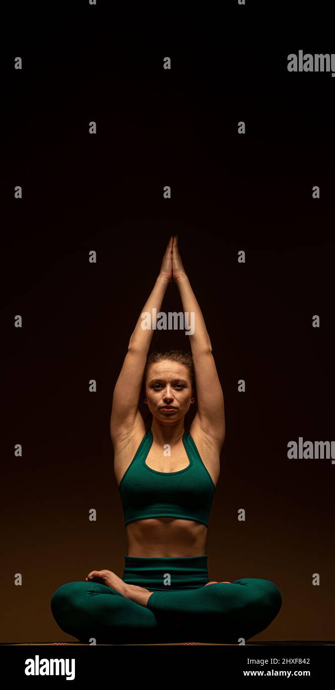 Attractive and beautiful young girl is doing the lotus position on the ...