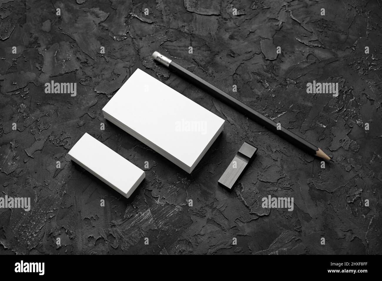 Photo of business cards, pencil, eraser and usb flash drive on black ...