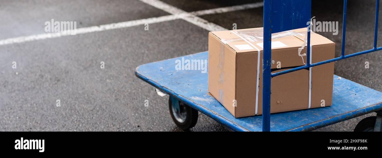 Brown cardboard moving box in the cart Stock Photo - Alamy