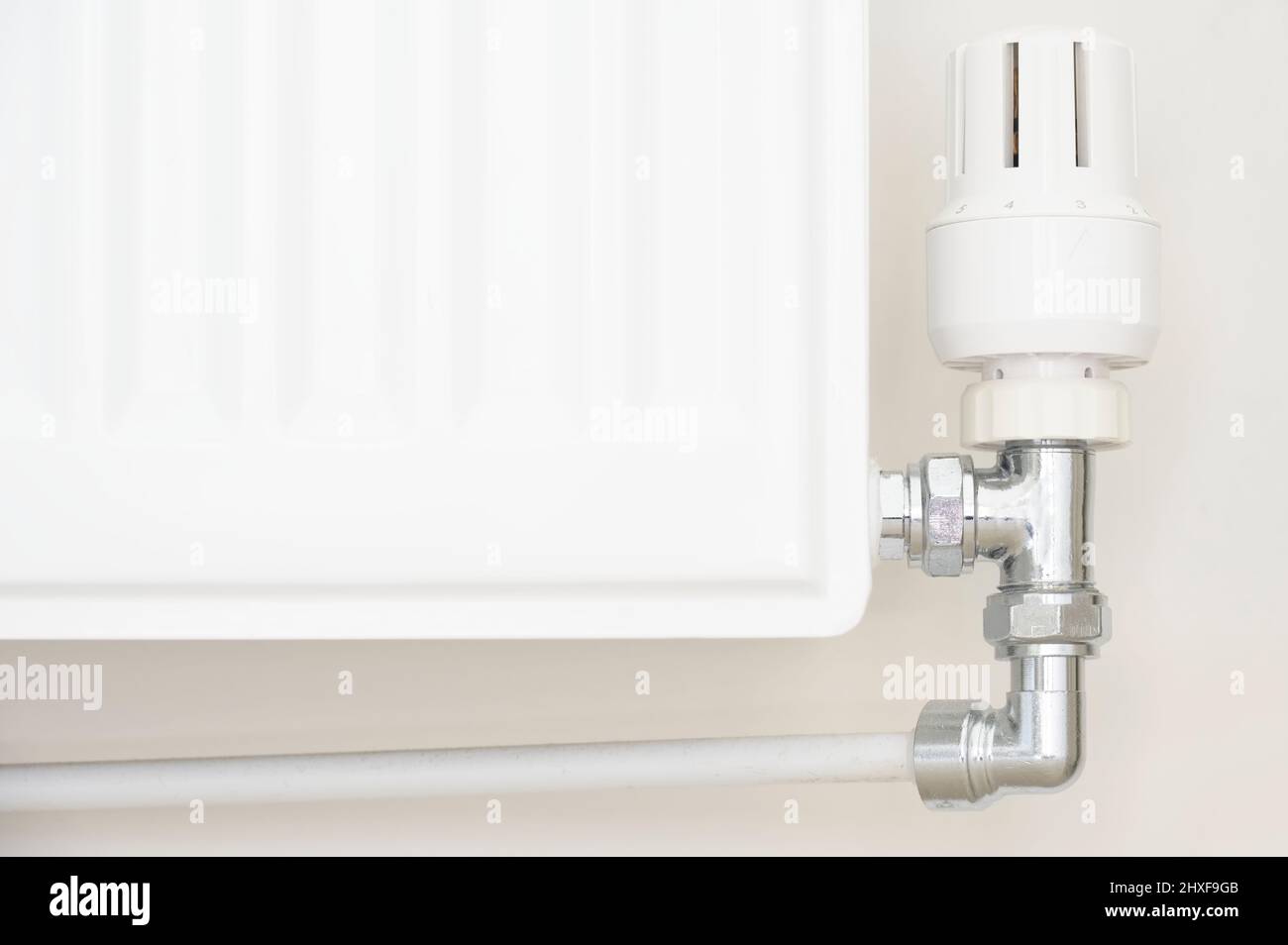 New white radiator white on pale wall house interior Stock Photo - Alamy