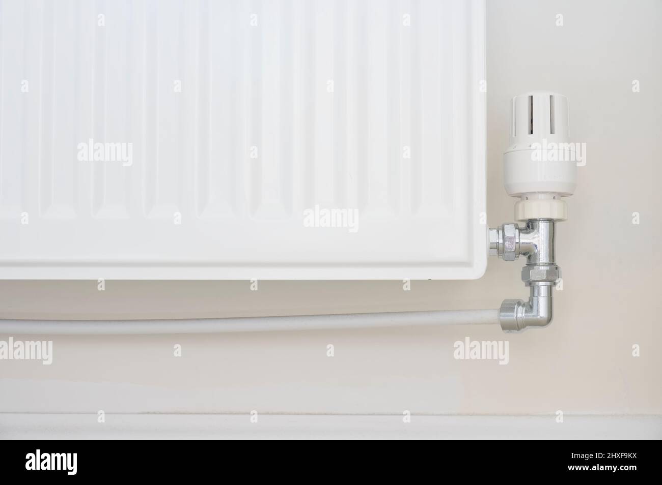 New white radiator white on pale wall house interior Stock Photo - Alamy