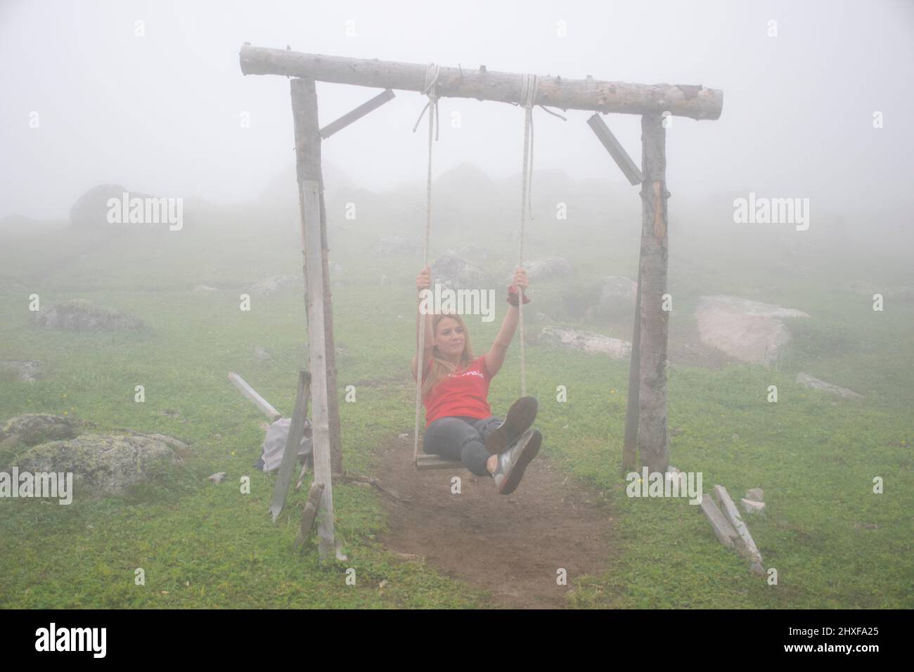 Girl swinging on a swing in a natural shade and a foggy field Stock ...