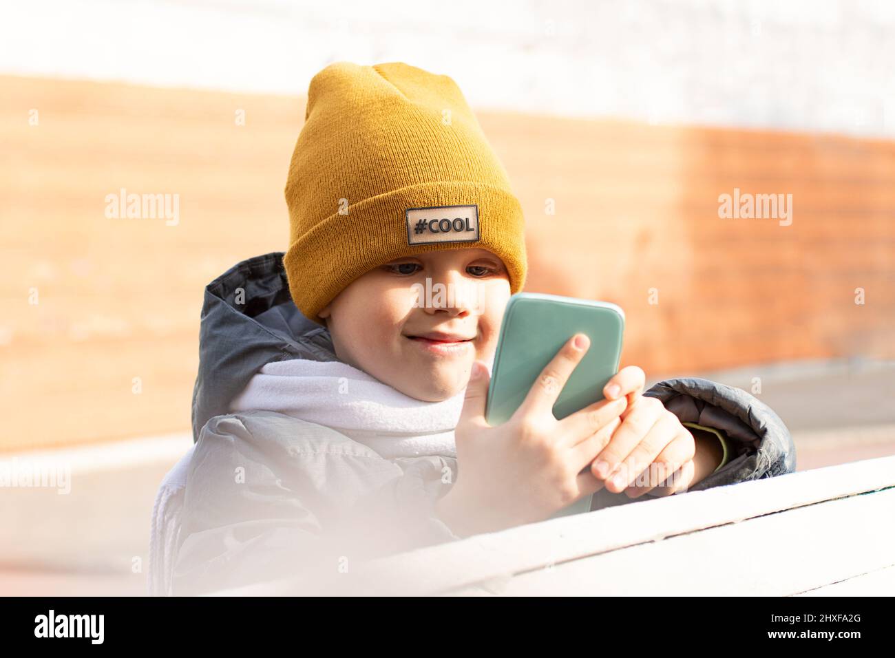 Cute boy smile and use smartphone outdoor Stock Photo - Alamy