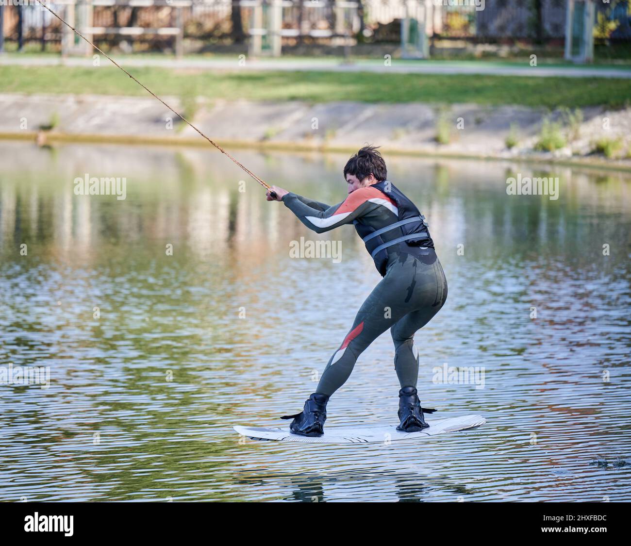 Wakeboarder surfing on lake. Young man surfer having fun wakeboarding ...