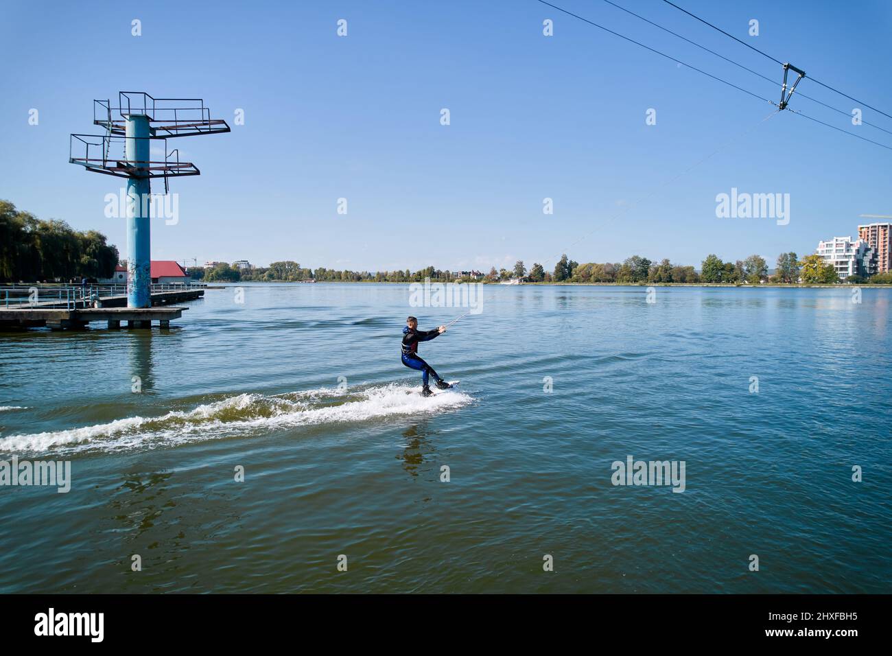Wakeboarder surfing on lake. Young surfer having fun wakeboarding in ...