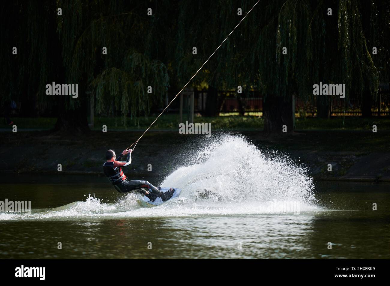 Wakeboarder surfing on lake. Young man surfer having fun wakeboarding ...