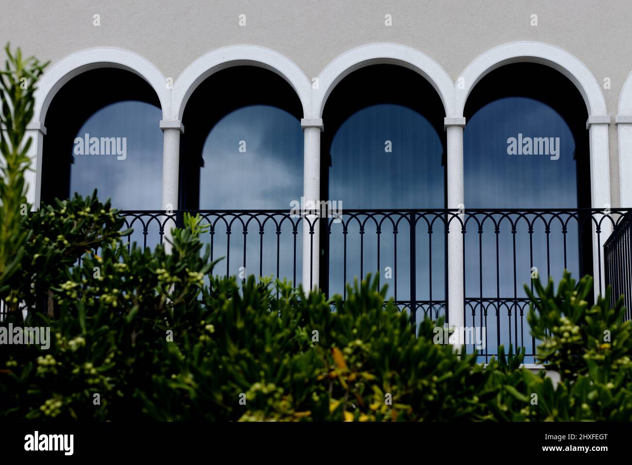 Round shaped windows of luxury villa with green bush in front of it ...