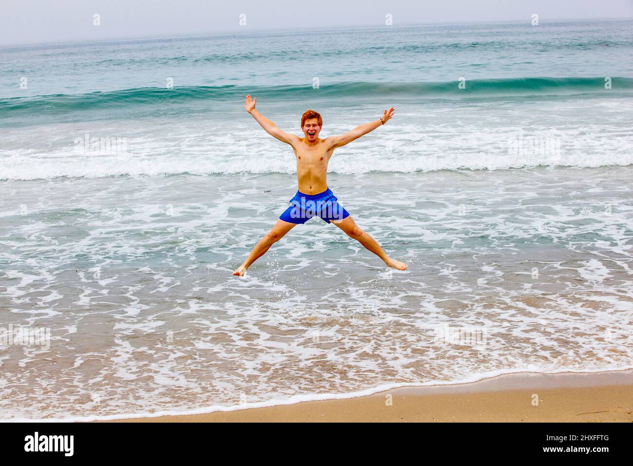 boy jumps in the air at the beach Stock Photo - Alamy