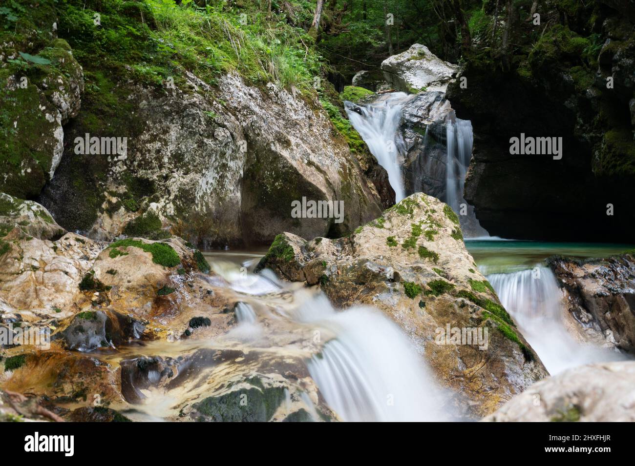 Blurred image of beautiful stream of water running over cascades and ...