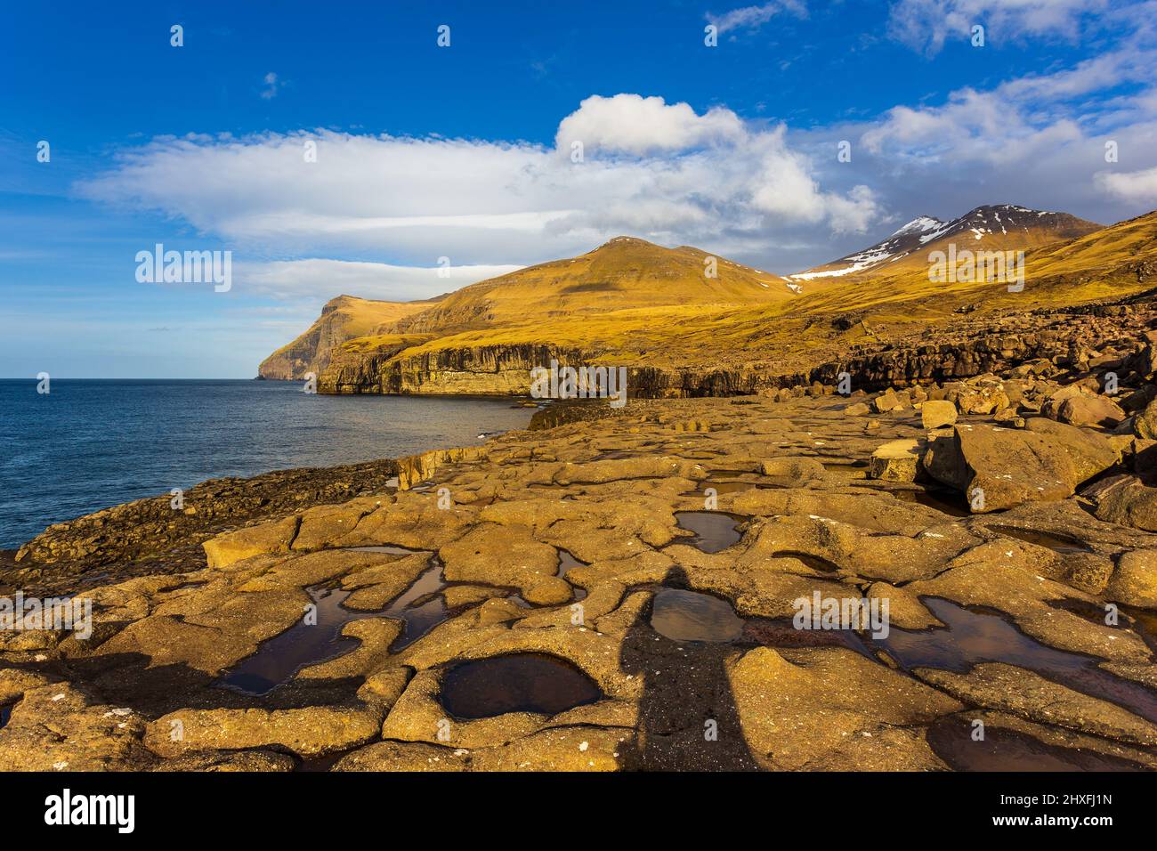 Steep coast of the islands of Eidi on Streymoy Island. Volcanic ...