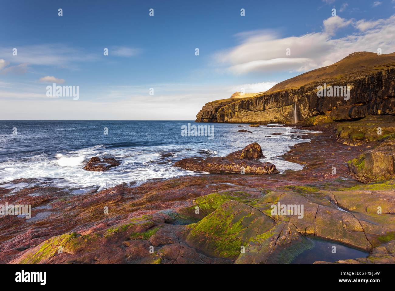 Steep coast of the islands of Eidi on Streymoy Island. Volcanic ...