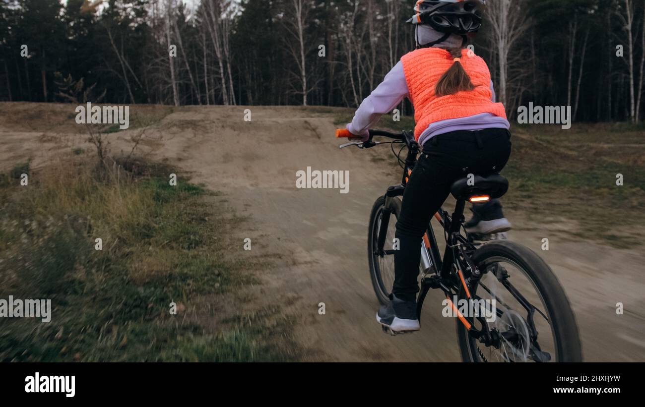 One caucasian children rides bike road track in dirt park. Girl riding ...