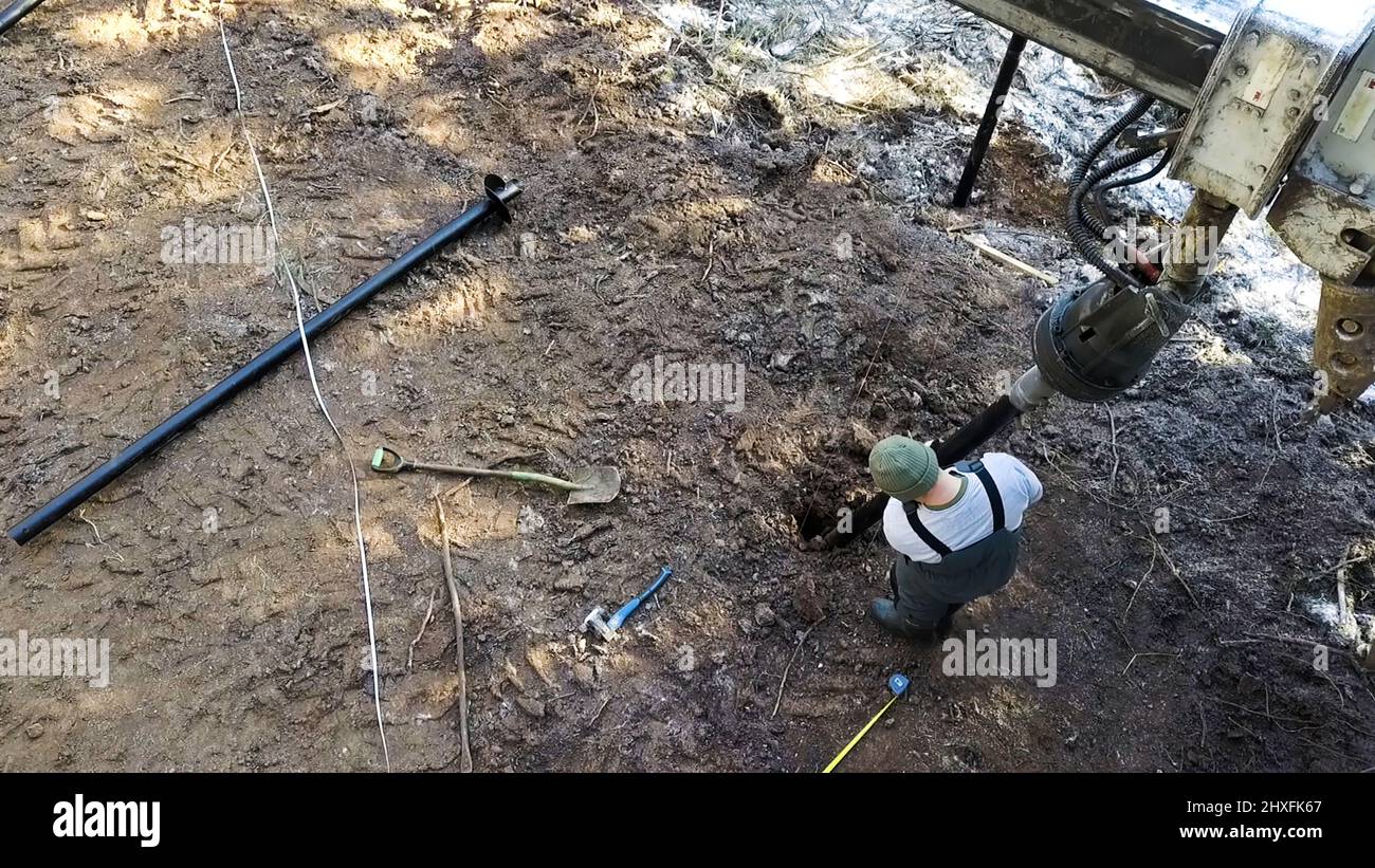Workflow. Clip. Laying of pipelines . A man in a helmet does work with ...