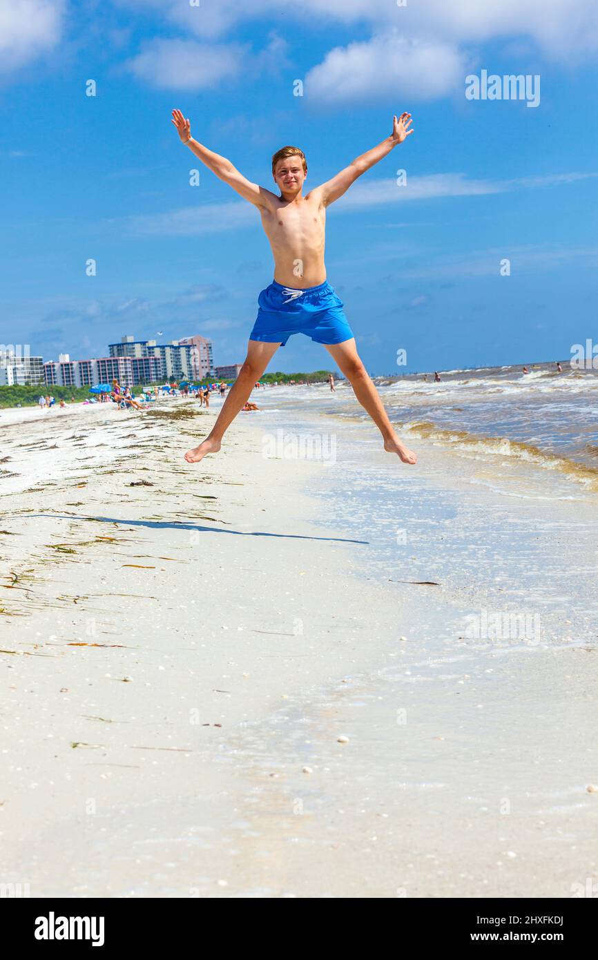 boy jumps in the air at the beach Stock Photo - Alamy