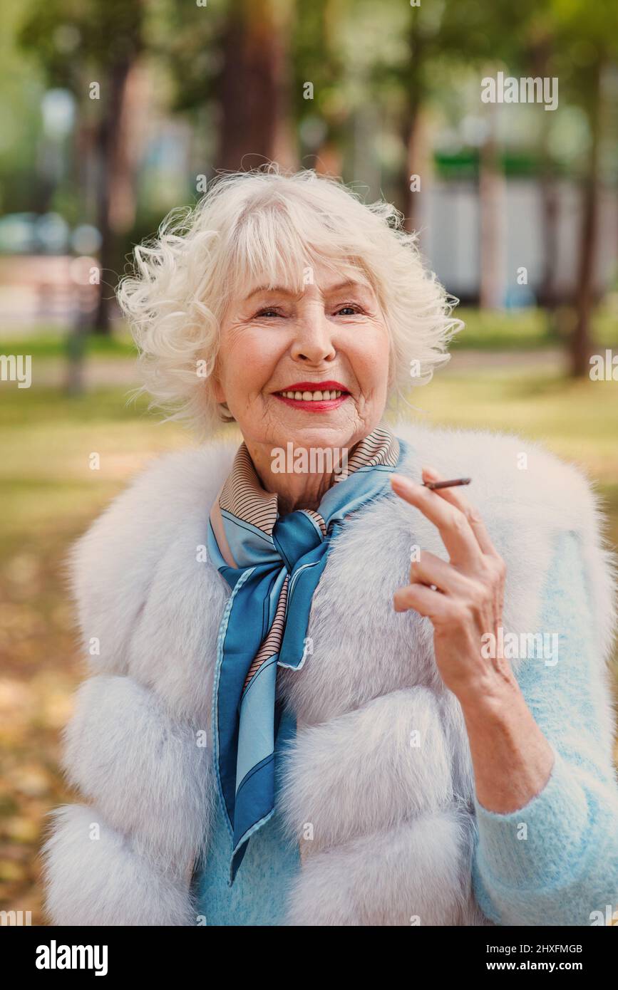 smiling senior elegant stylish fashionable woman with grey hair in fur ...
