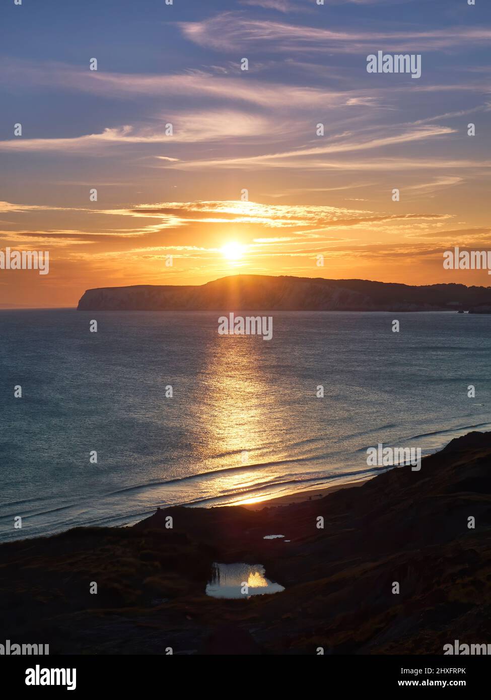 A radiant sunset over sea and chalk cliff headlands with rich golden ...