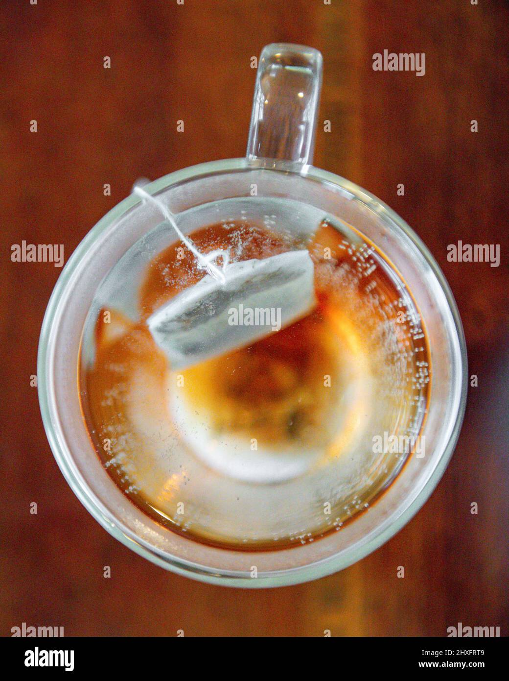 Brewing tea bag in water - caffeine drink in double glass walled tea ...