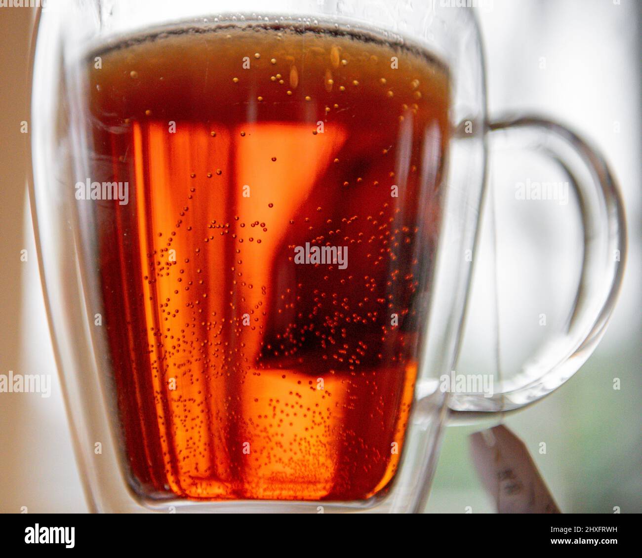Brewing tea bag in water - caffeine drink in double glass walled tea ...