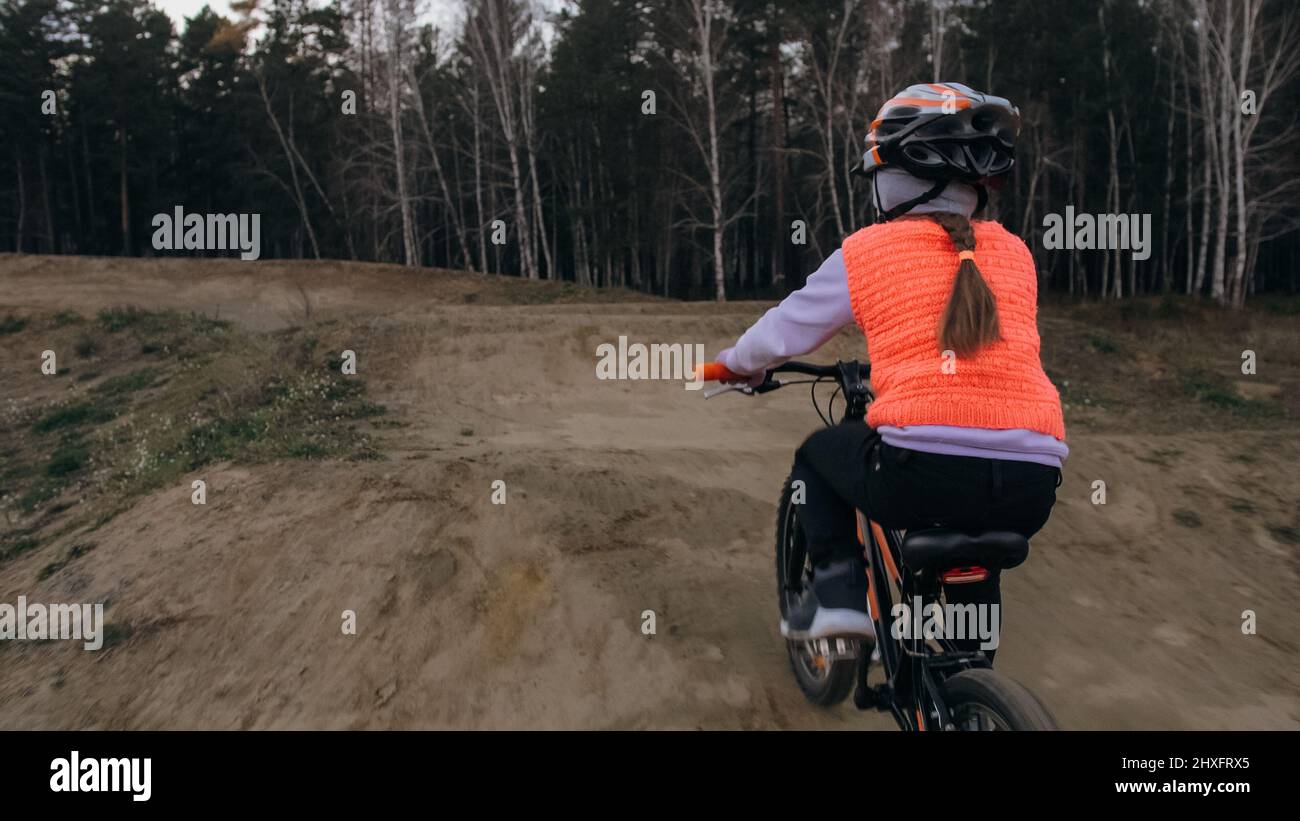 One caucasian children rides bike road track in dirt park. Girl riding ...