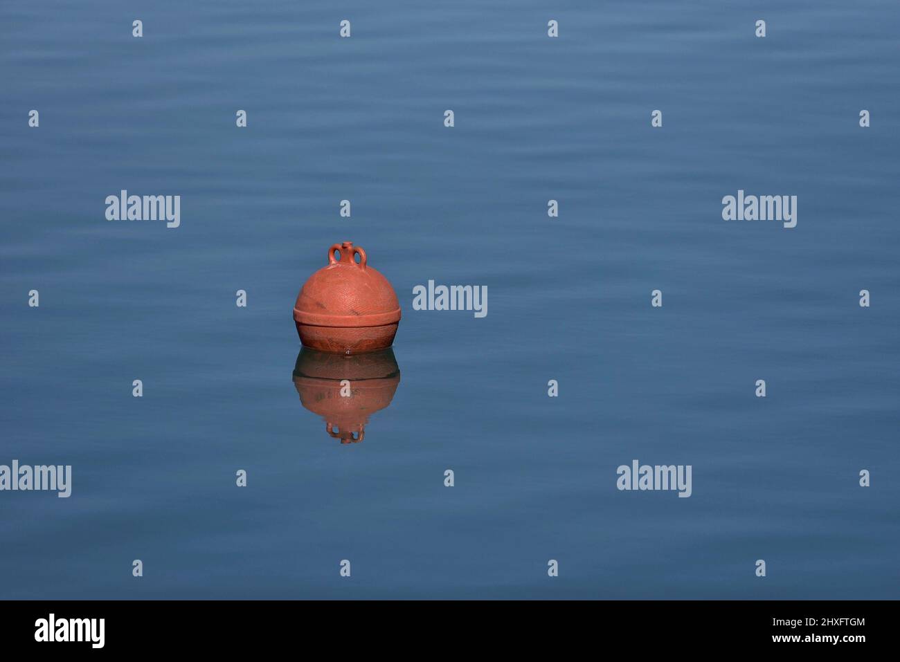 Orange heavy duty balloon fender on the blue waters of Nafplio in ...