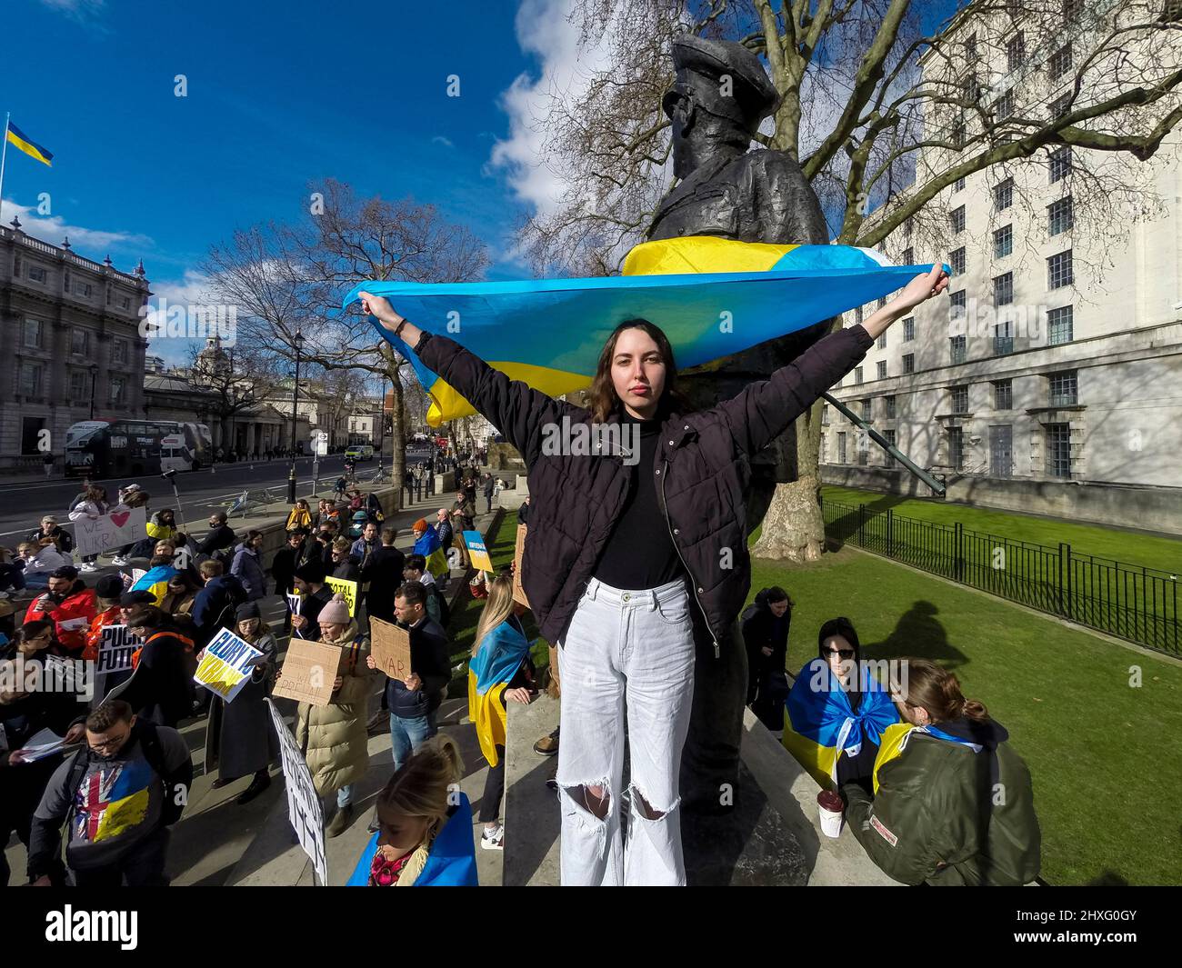London, UK. 12 March 2022. A demonstrator holding up a Ukrainian flag ...