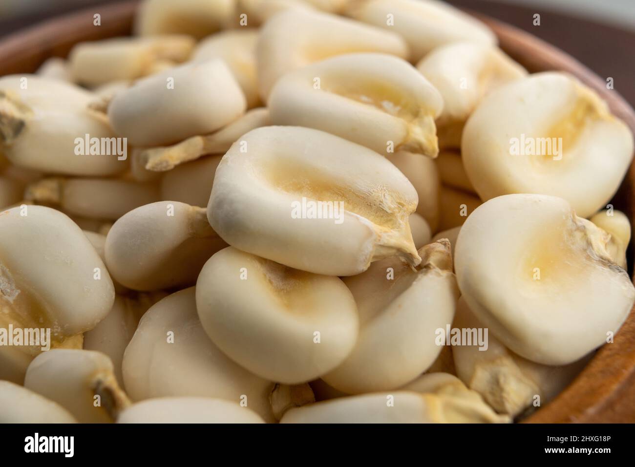 Whole dried hominy. Dry maize mote grain in wooden bowl. Macro Stock ...