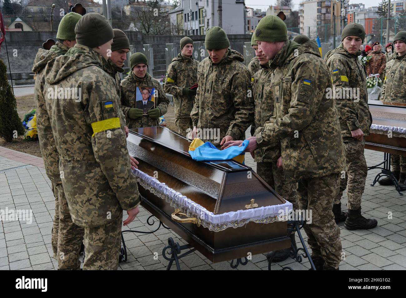 Ukrainian servicemen cover a coffin of Ukrainian soldier who was killed ...