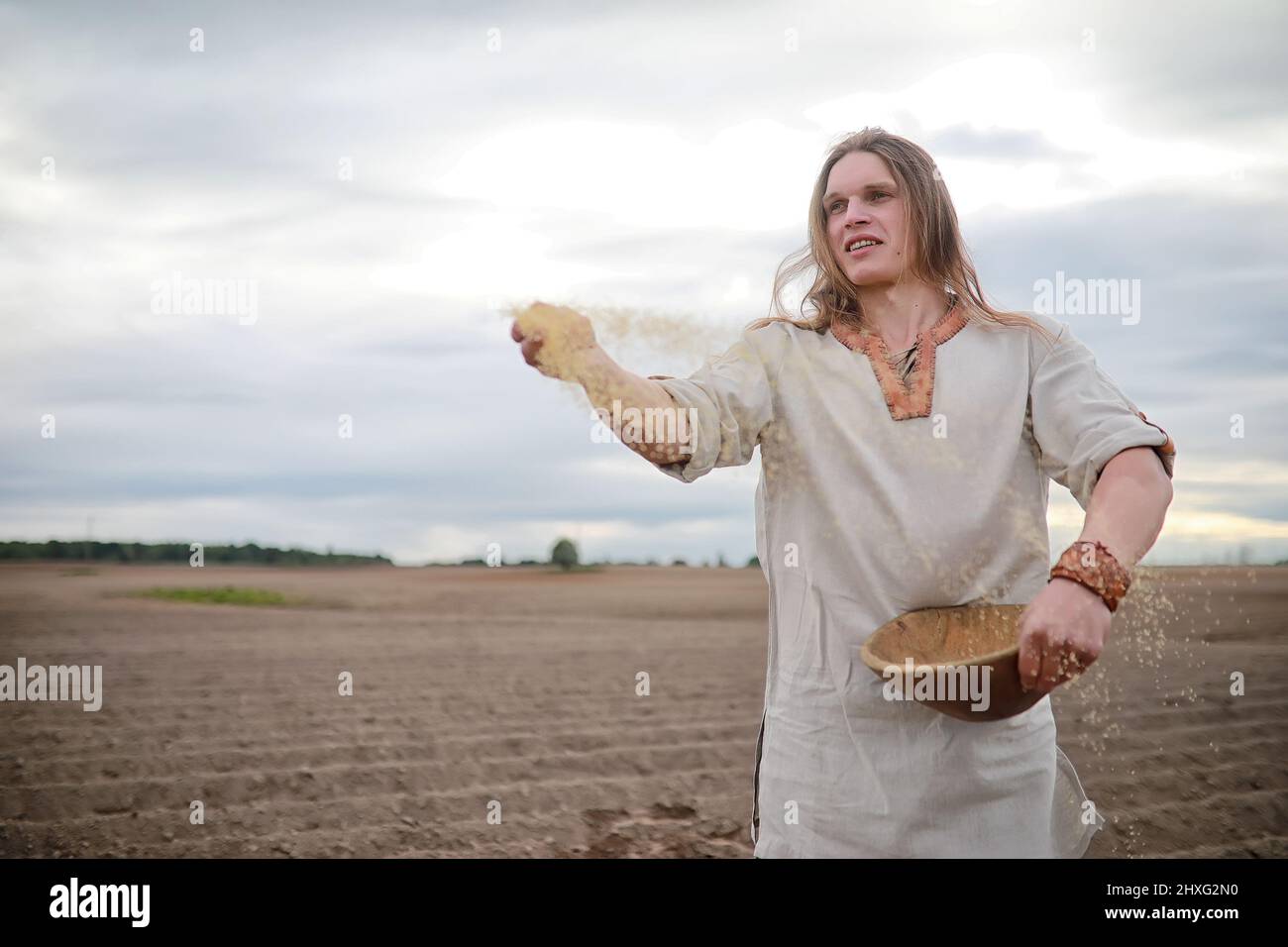 A young peasant of the Scandinavian appearance sows the field with ...