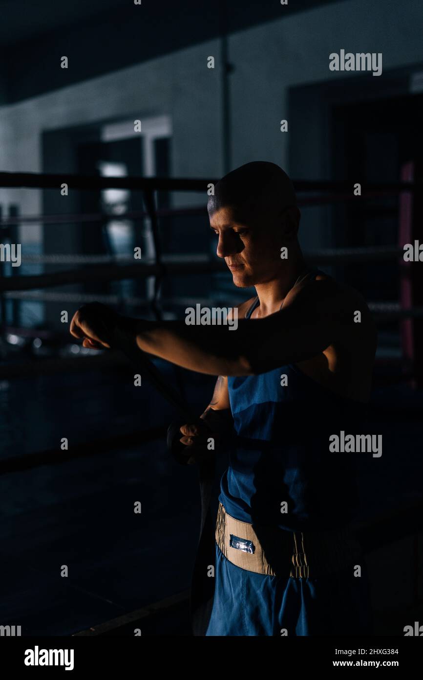 Vertical shot of confident boxer wrapping defense boxing tape around ...