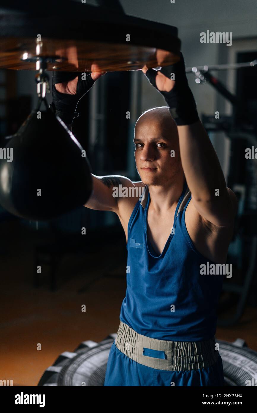 Vertical portrait of exhausted bald boxer male in boxing defence tape ...