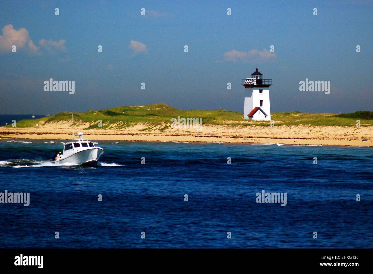A pleasure craft cruises past the Long Point Lighthouse, off the coast ...