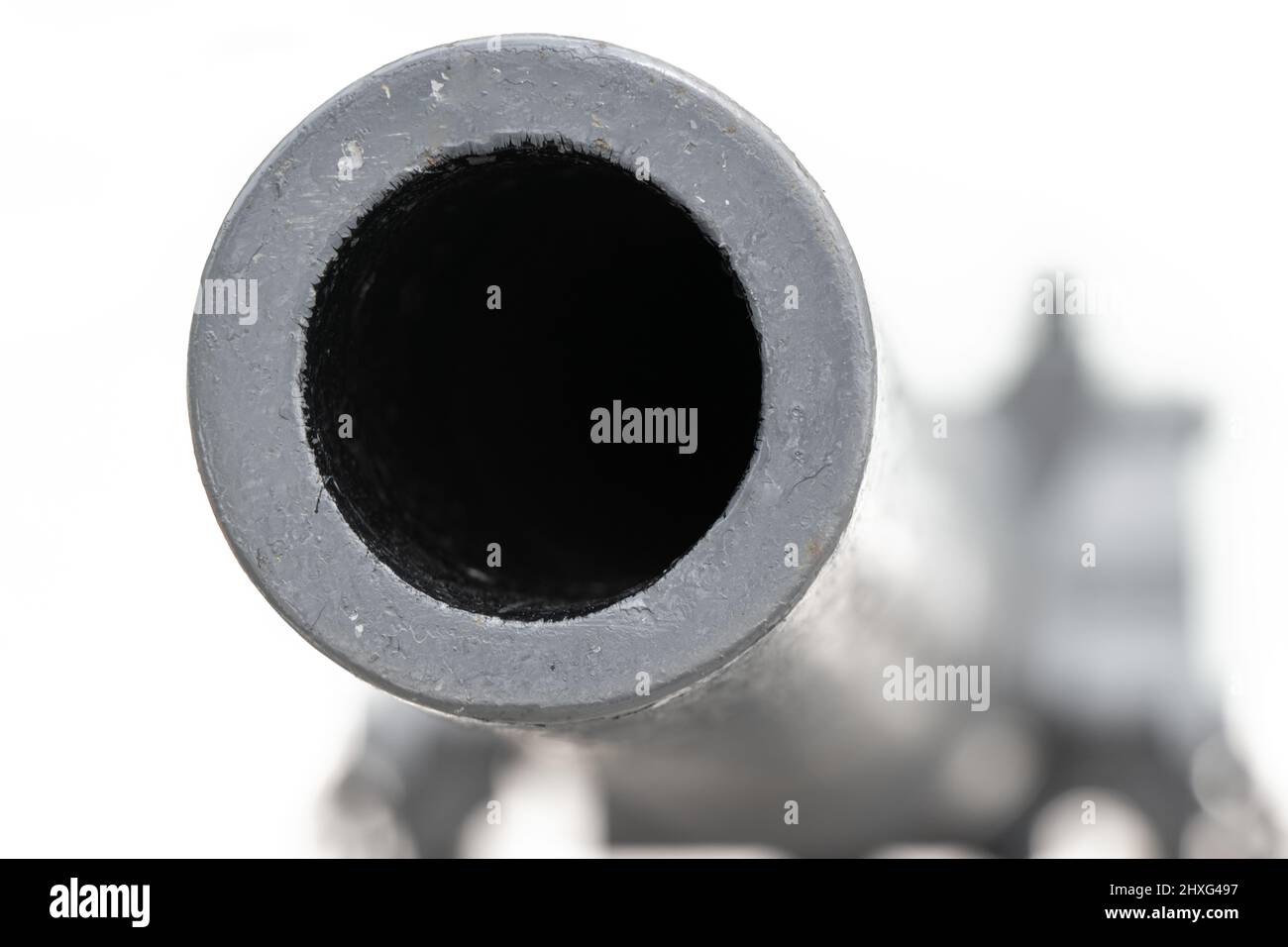 The barrel of the cannon aims front into a camera, on a white ...
