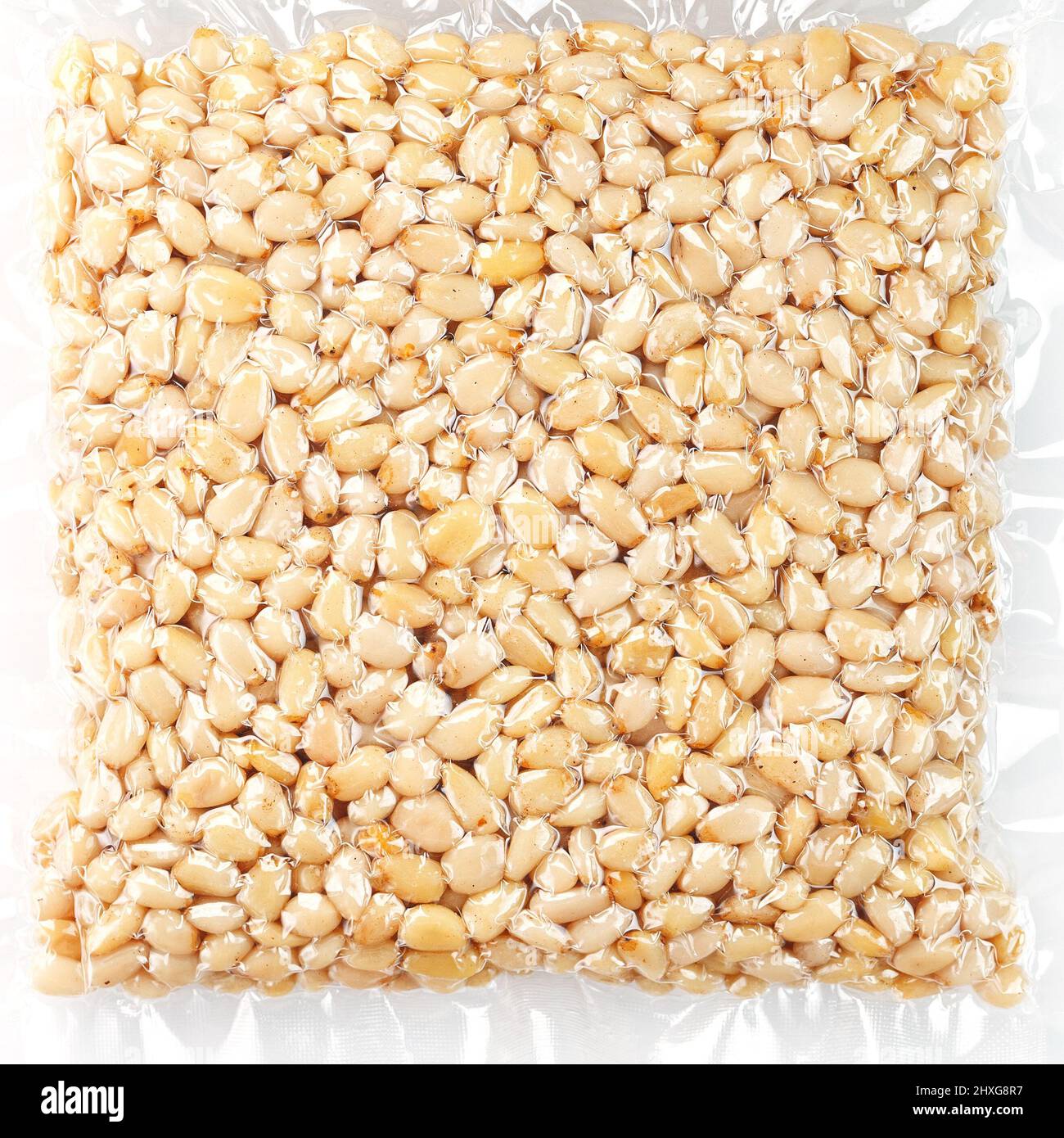 Peeled pine nuts in vacuum packaging on a white background with a free ...