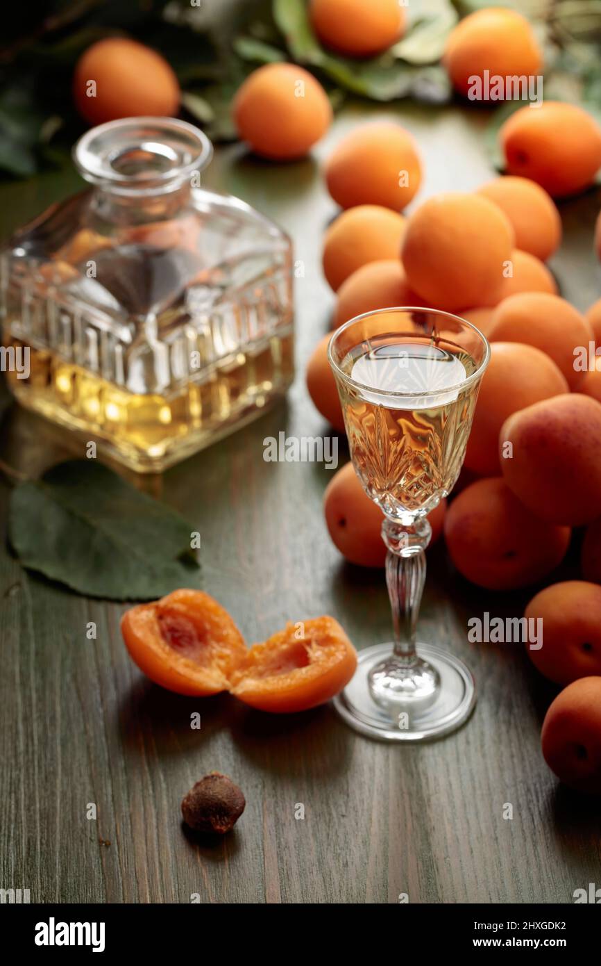 Apricot liquor with fresh fruits on a wooden table Stock Photo - Alamy