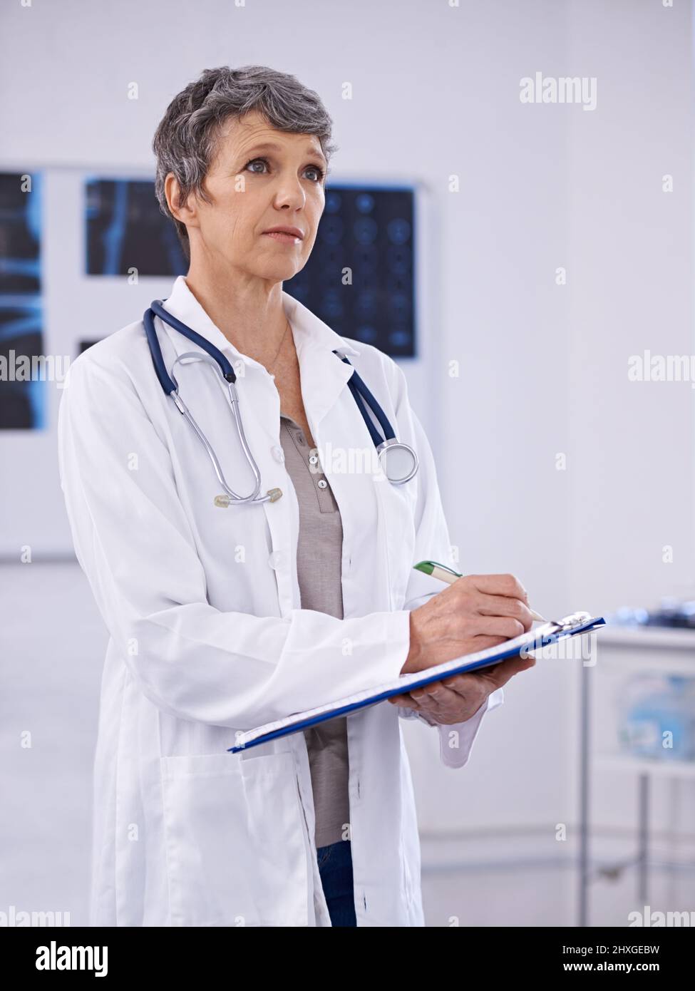 Careful observation in medicine. Shot of a female doctor holding a ...