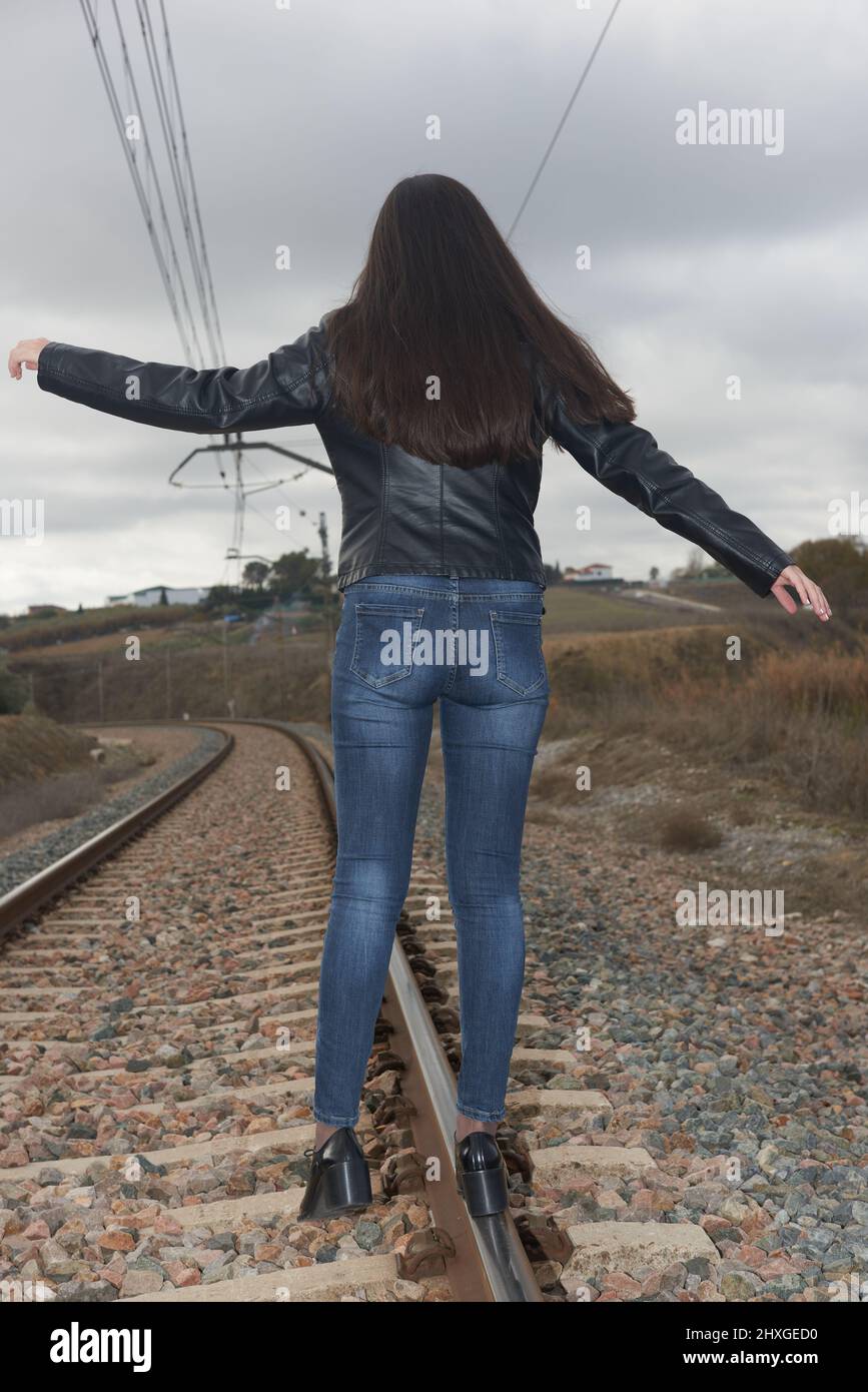 A daring and beautiful woman balancing on train rails Stock Photo - Alamy