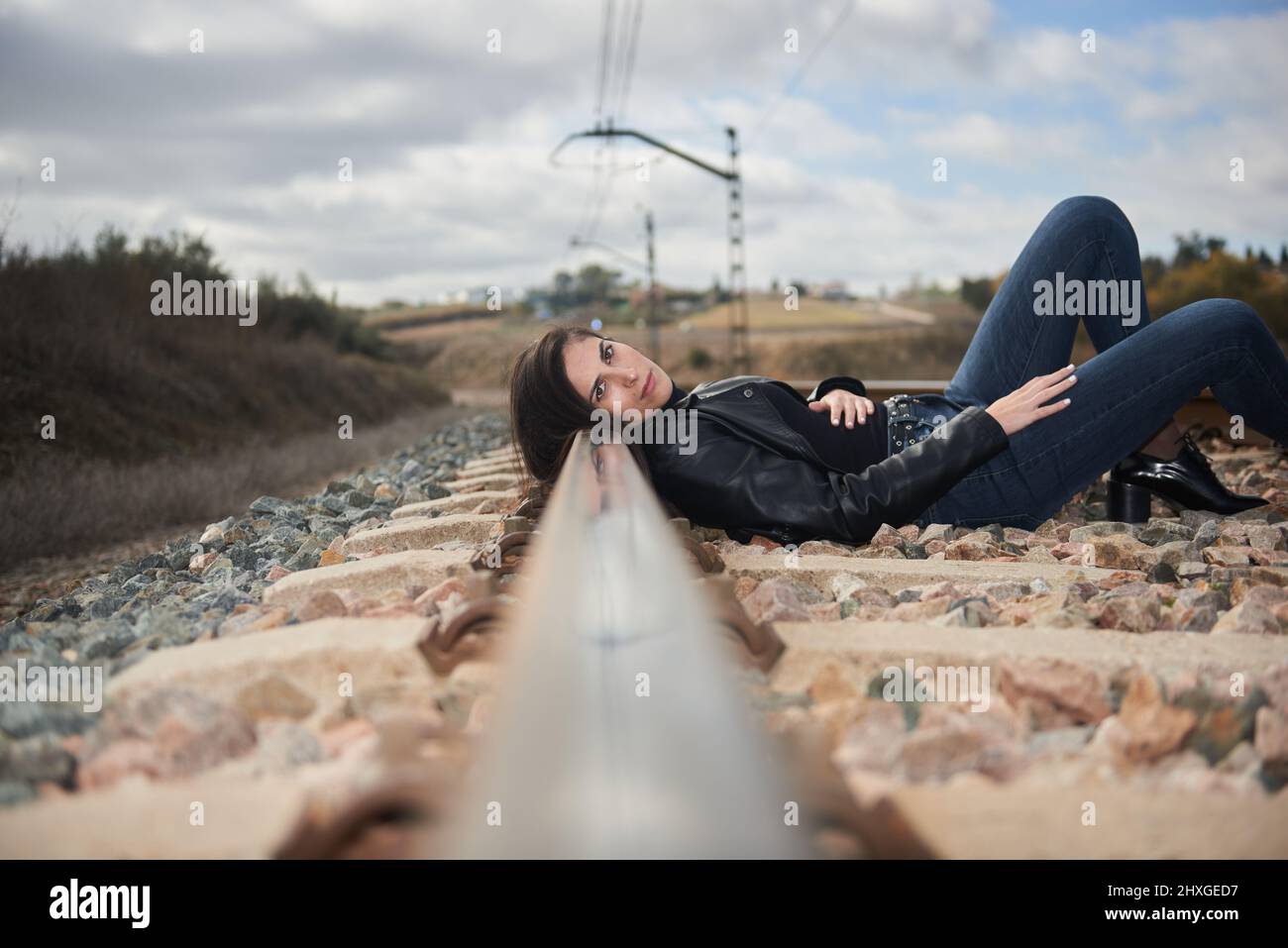 An attractive girl lying quietly on the rails of the train Stock Photo ...