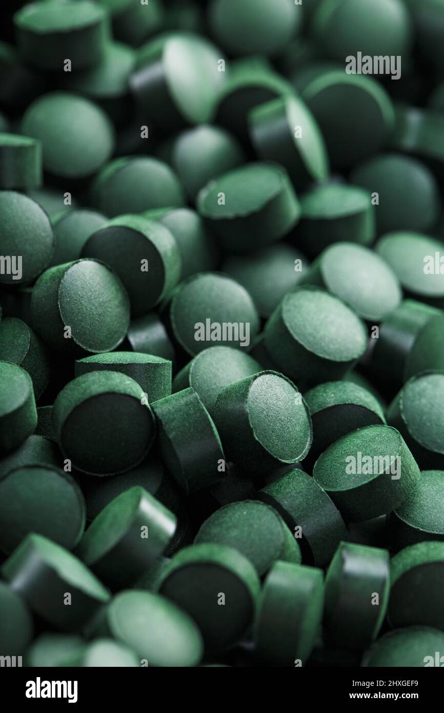 Close-up of Green tablets of organic spirulina as a texture background ...