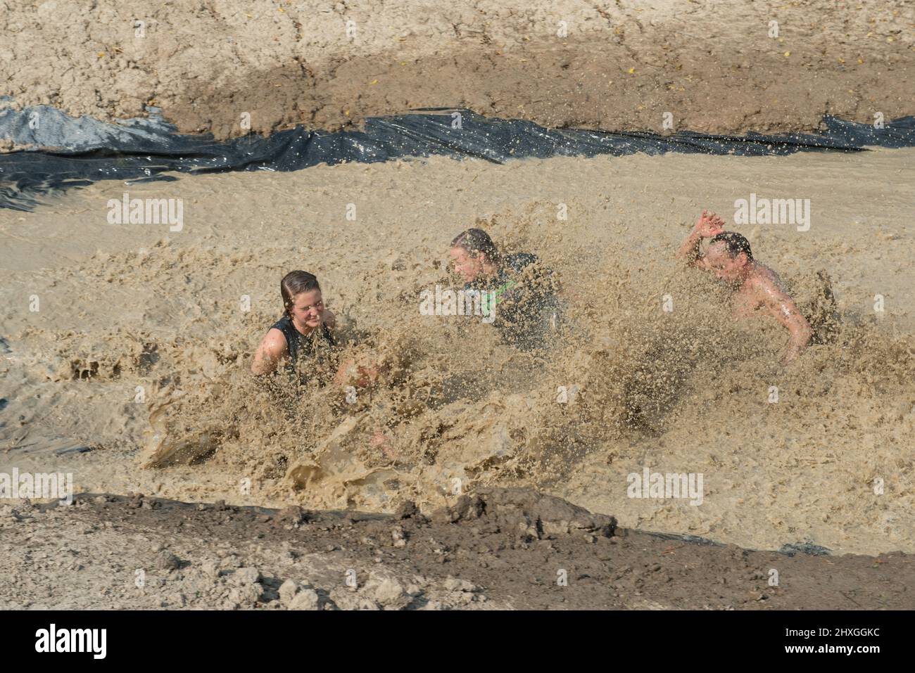 Three women slide into the mud pit of the Swampfoot Run in St. Clair ...