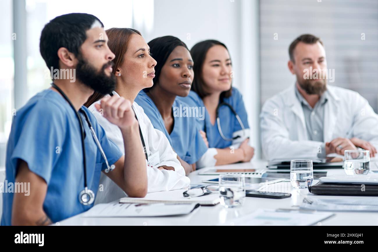 Working together to plan a patients care. Shot of a doctor sitting ...