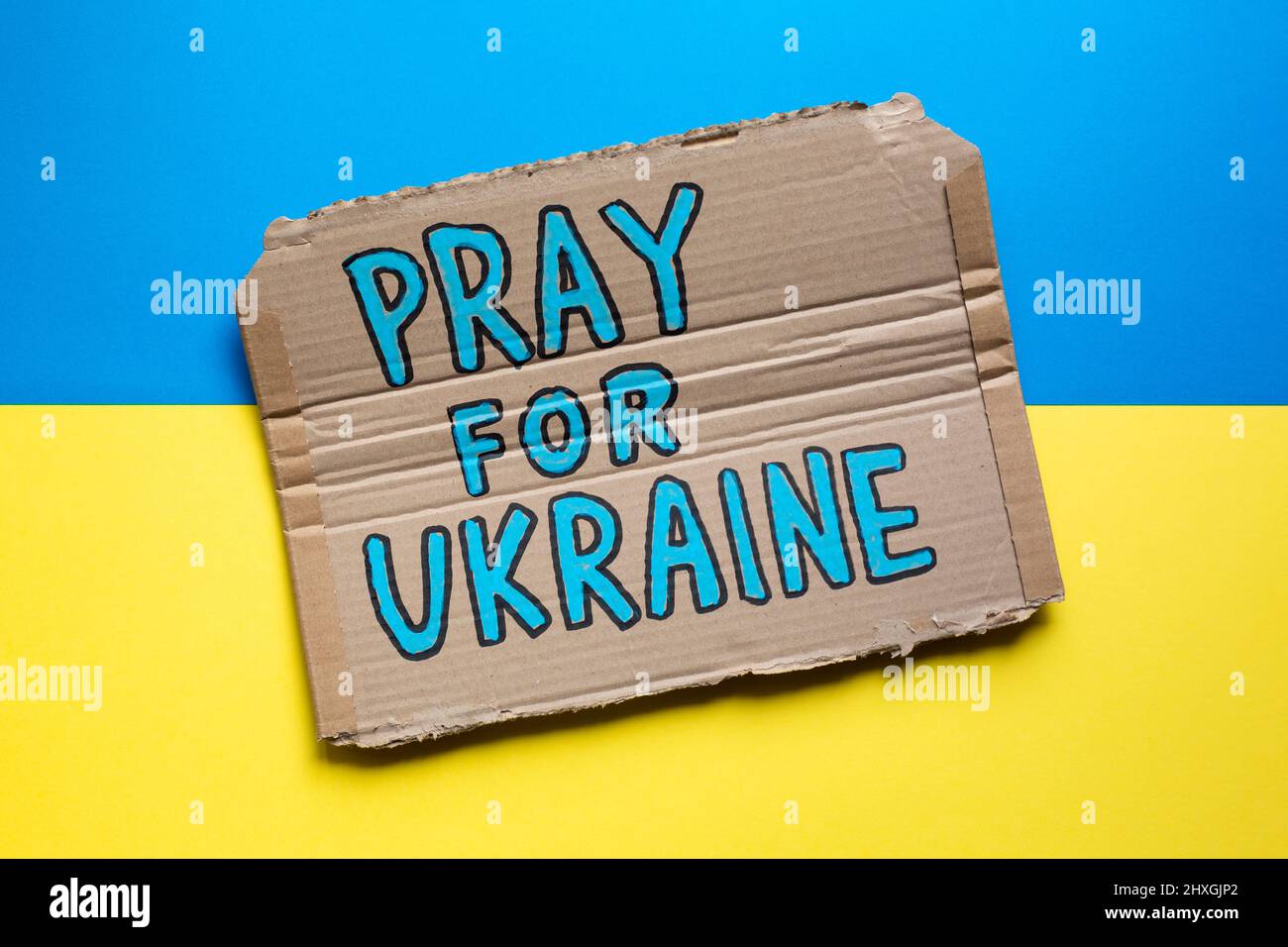 Hand drawn sign with Pray For Ukraine slogan on Ukrainian flag Stock ...