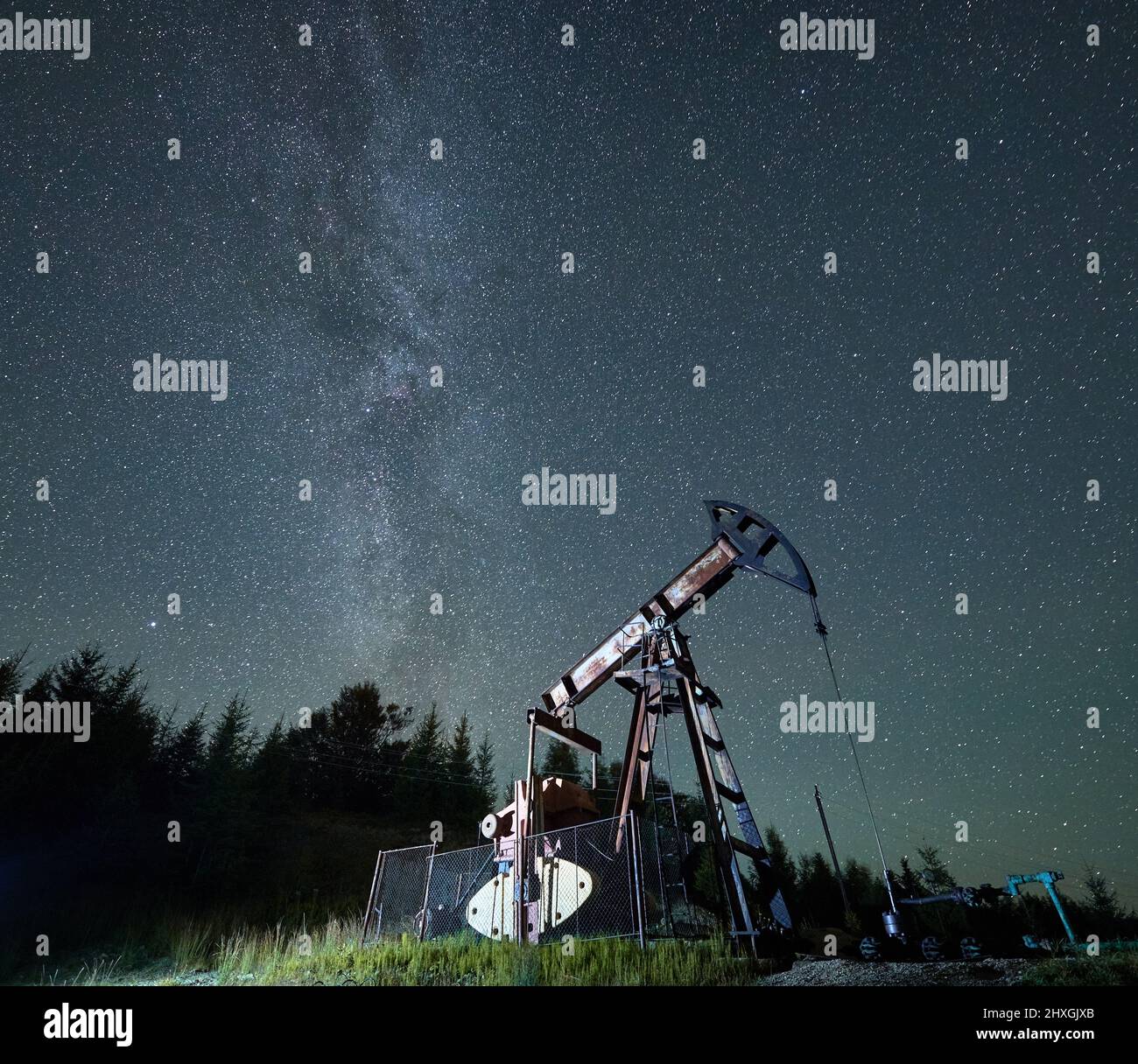 Beautiful view of petroleum pump jack under night sky with stars ...