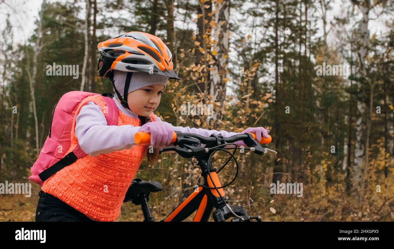 One caucasian children walk with bike in autumn park. Little girl ...