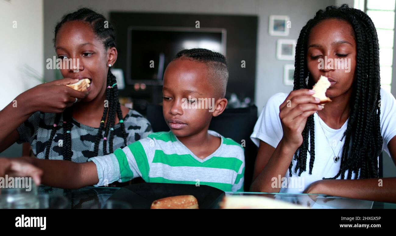 Children eating afternoon snack at home. Black African ethnicity kids ...