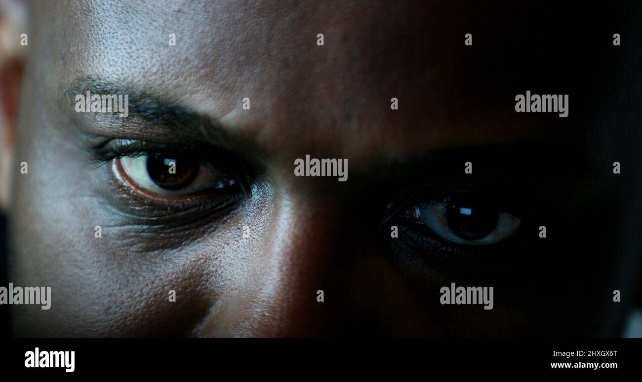 Close-up black man face and eyes looking at laptop computer screen at ...