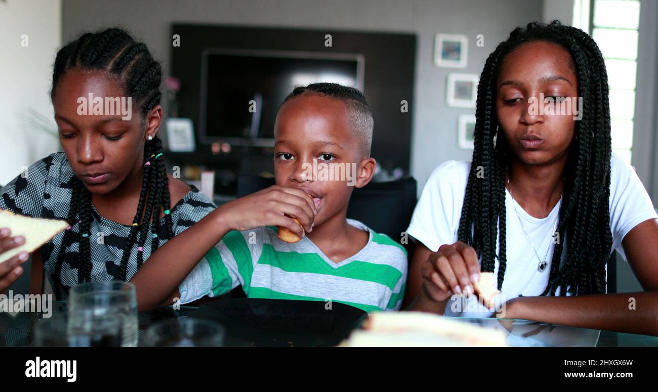 Children eating afternoon snack at home. Black African ethnicity kids ...