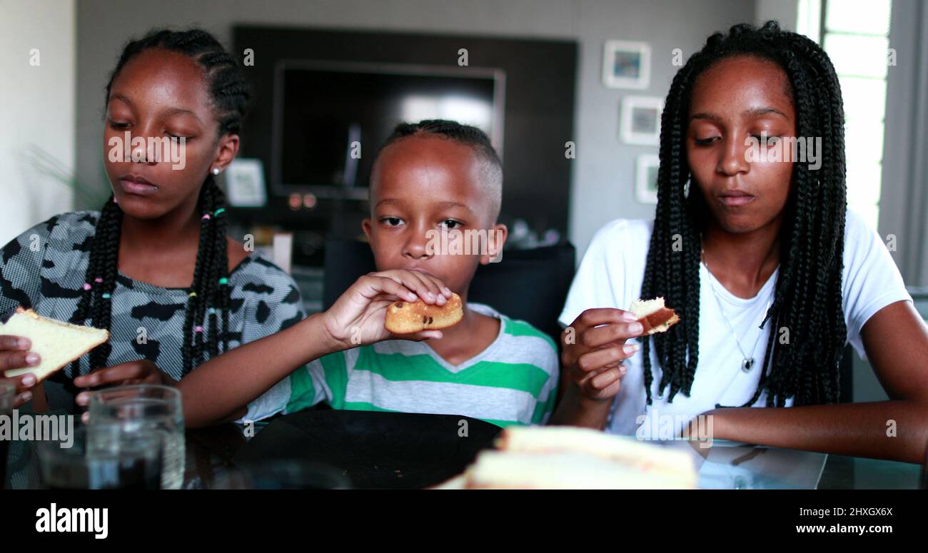 Children eating afternoon snack at home. Black African ethnicity kids ...