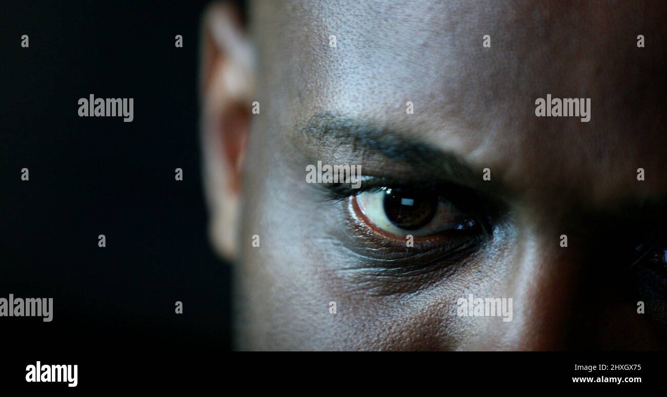 Close-up black man face and eyes looking at laptop computer screen at ...